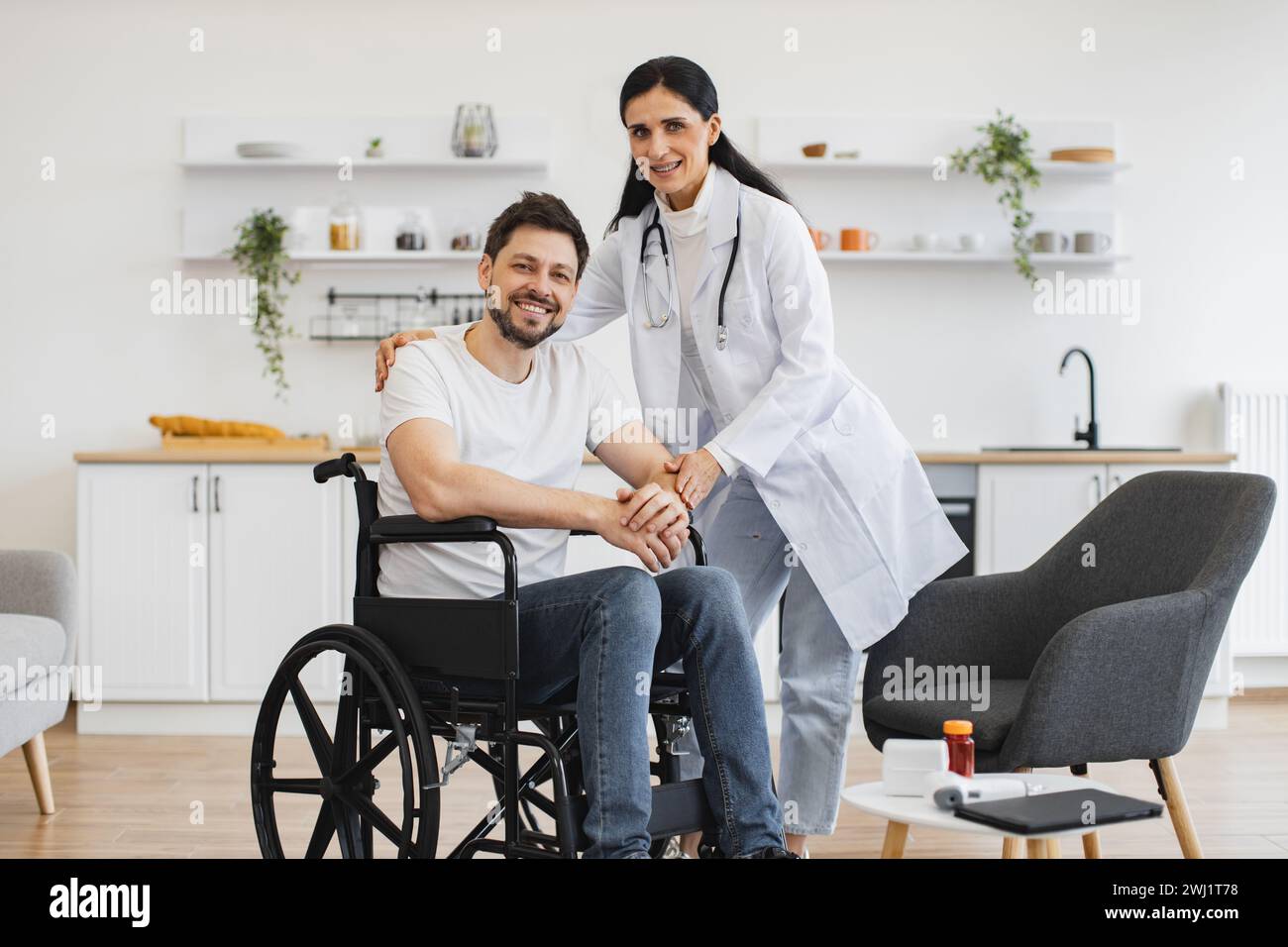 Female doctor hugging smiling male patient with disability posing at ...