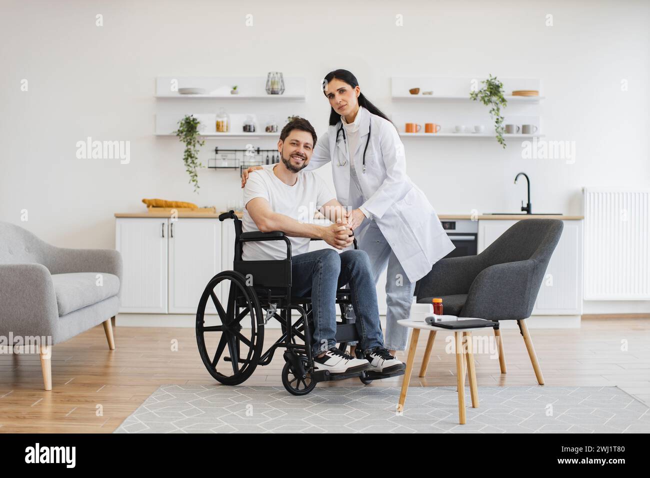 Female doctor hugging smiling male patient with disability posing at ...