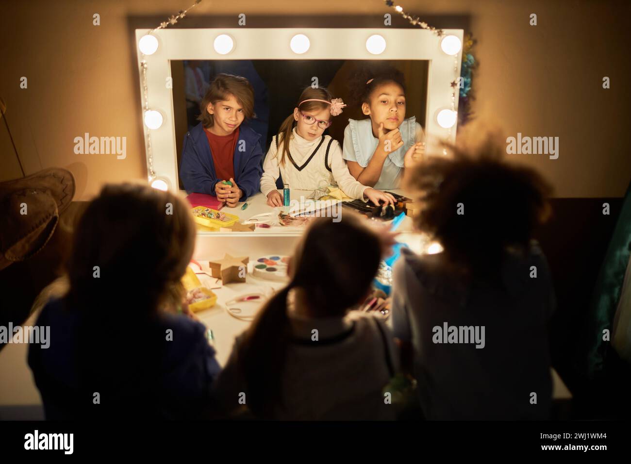 high angle portrait of three little children looking into mirror ...