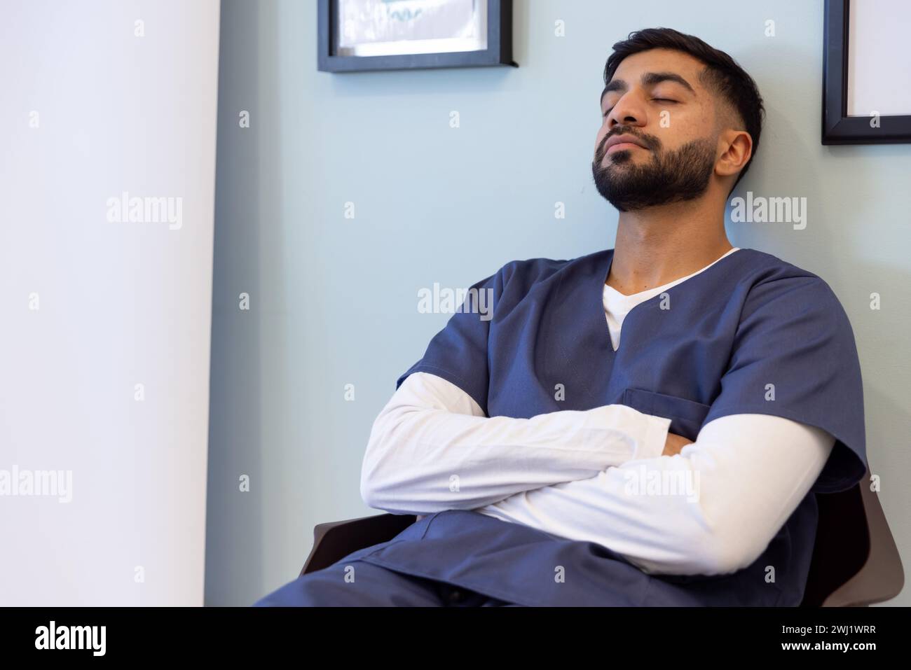 Biracial male doctor taking nap in hospital waiting room Stock Photo ...