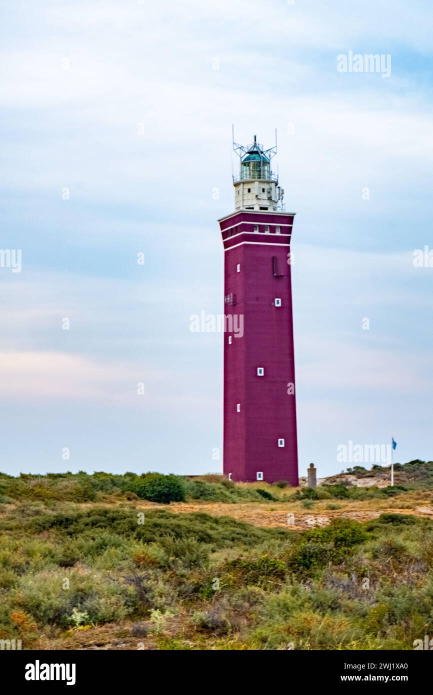 This image features a striking red lighthouse, its vivid color ...