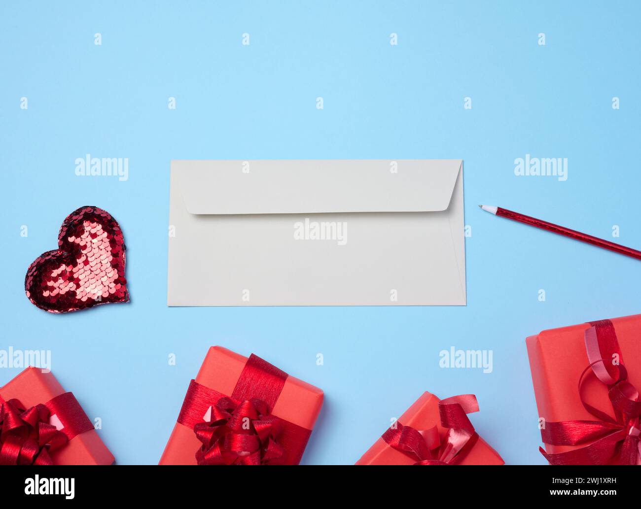 White paper envelope on a blue background, around a box with gifts, top ...