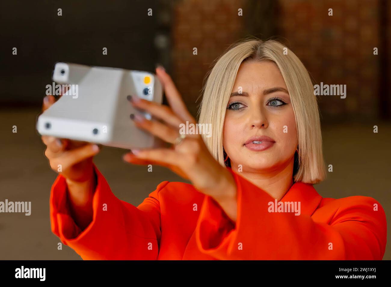 A Lovely Blonde Model Poses Outdoors Using Her Camera While Enjoying ...