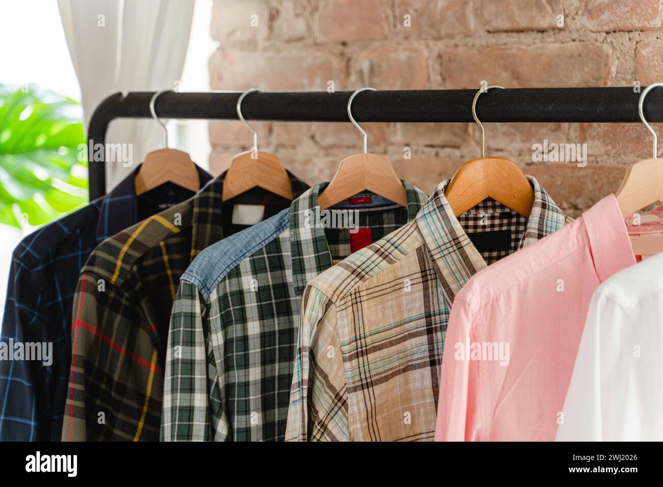 Clothing rack with variety of male shirts all hanging neatly on wooden ...