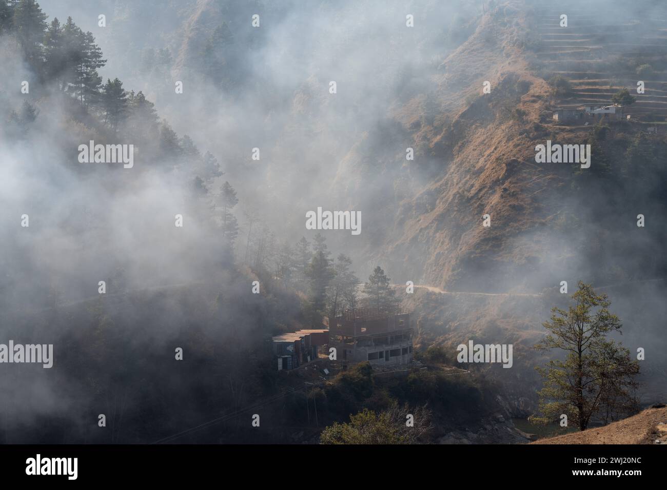 A wildfire burning a steep hillside in Nepal in the dry season with ...