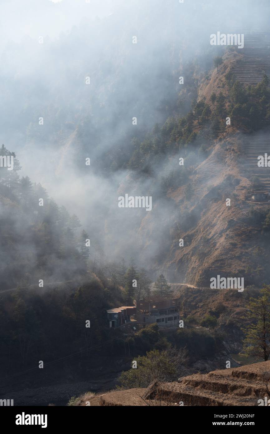 A wildfire burning a steep hillside in Nepal in the dry season with ...