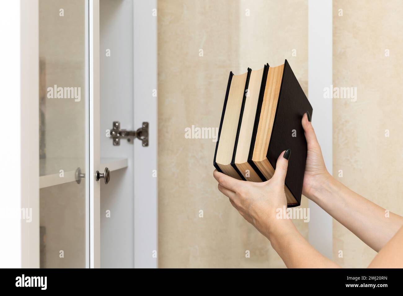 woman holding a book against the background of a bookcase. man takes ...