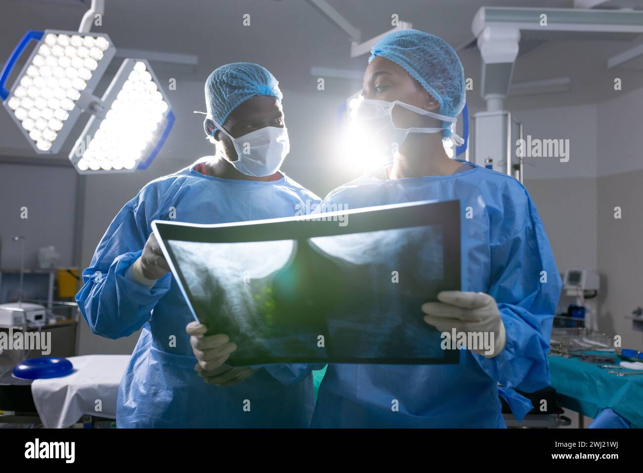 African american male and female doctors with face masks looking at x ...