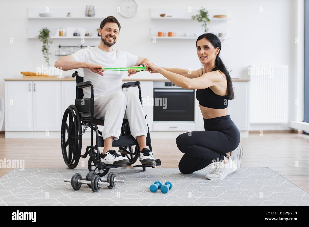 Portrait of female fitness trainer and male patient with disability ...