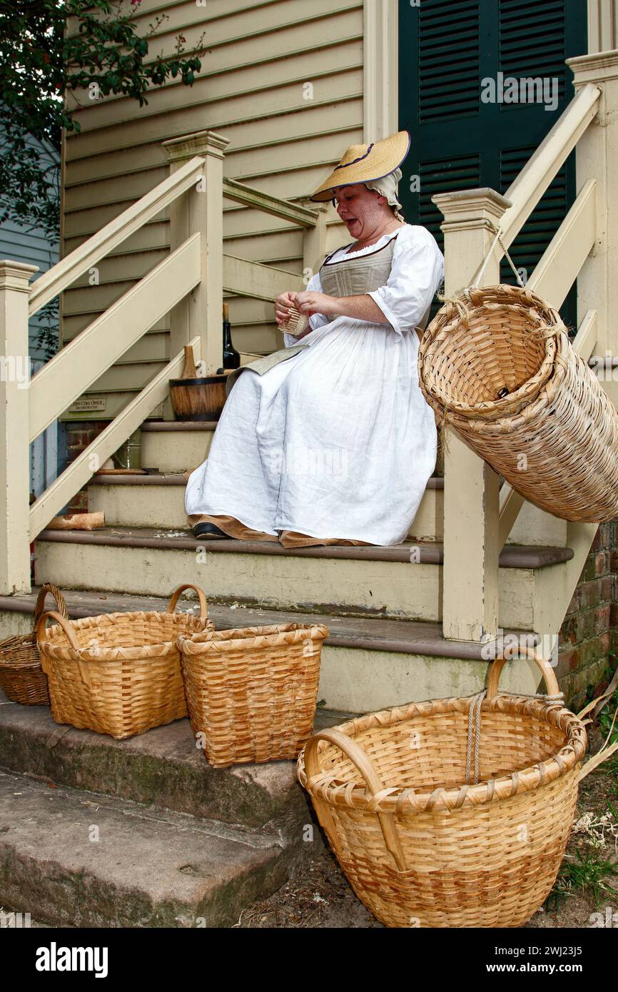 historic interpreter, making straw basket, colonial dress, sitting on ...