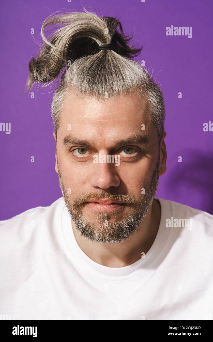 Middle aged man with funny pony tail against purple background Stock ...
