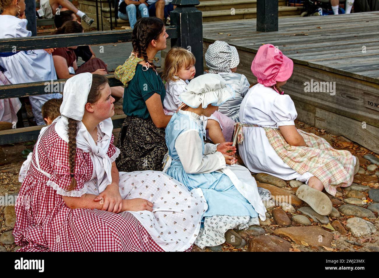 girls, dressed in colonial clothes, woman, sitting on cobblestones ...