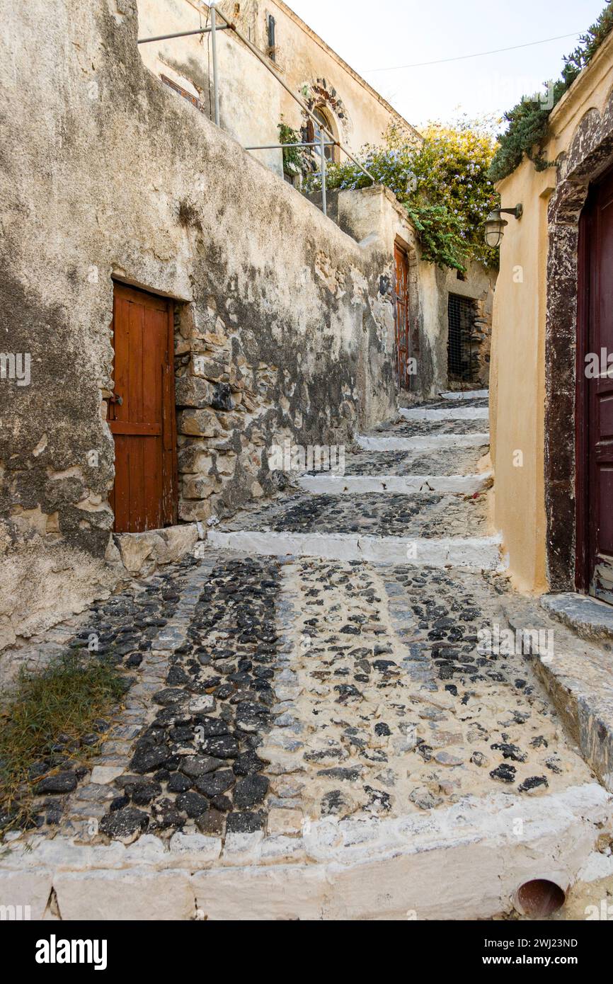 Typical narrow stone stepped lane between weathered rustic walls and ...