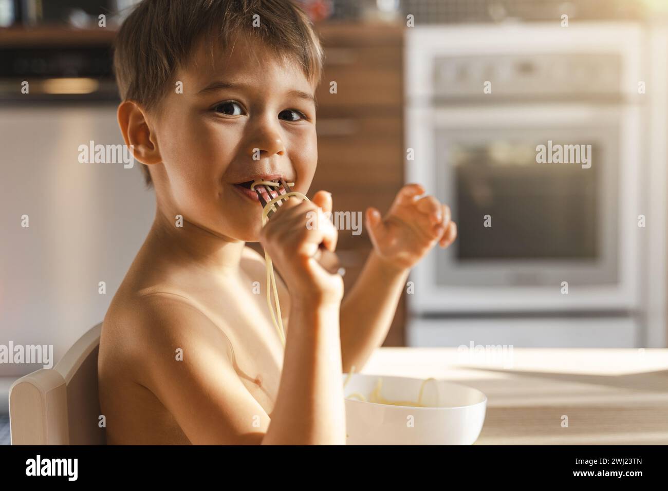 Cute toddler boy eating his favorite food - Spaghetti Stock Photo - Alamy