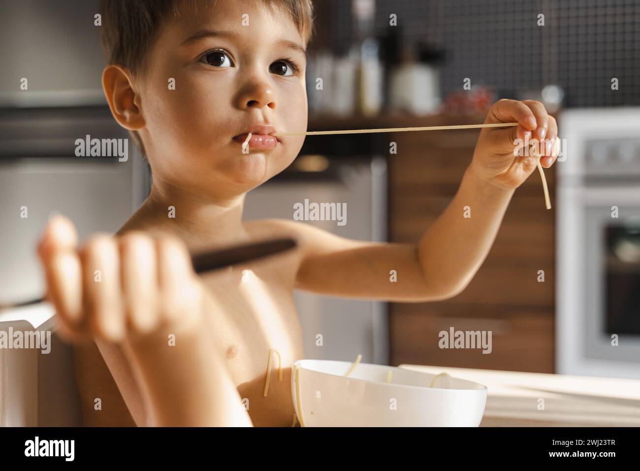 Cute toddler boy eating his favorite food - Spaghetti Stock Photo - Alamy
