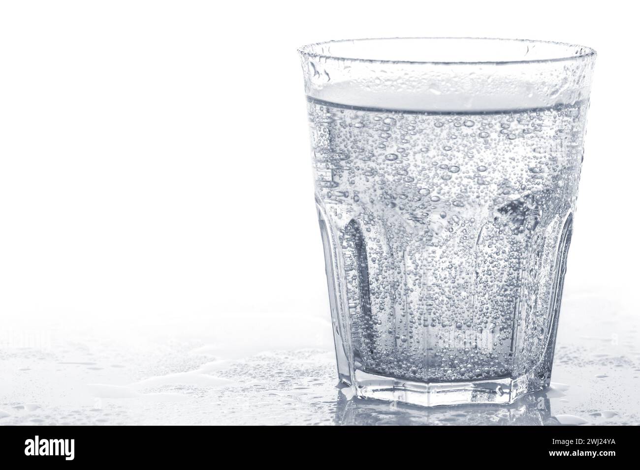 Glass of sparkling soft drink or carbonated water against white ...