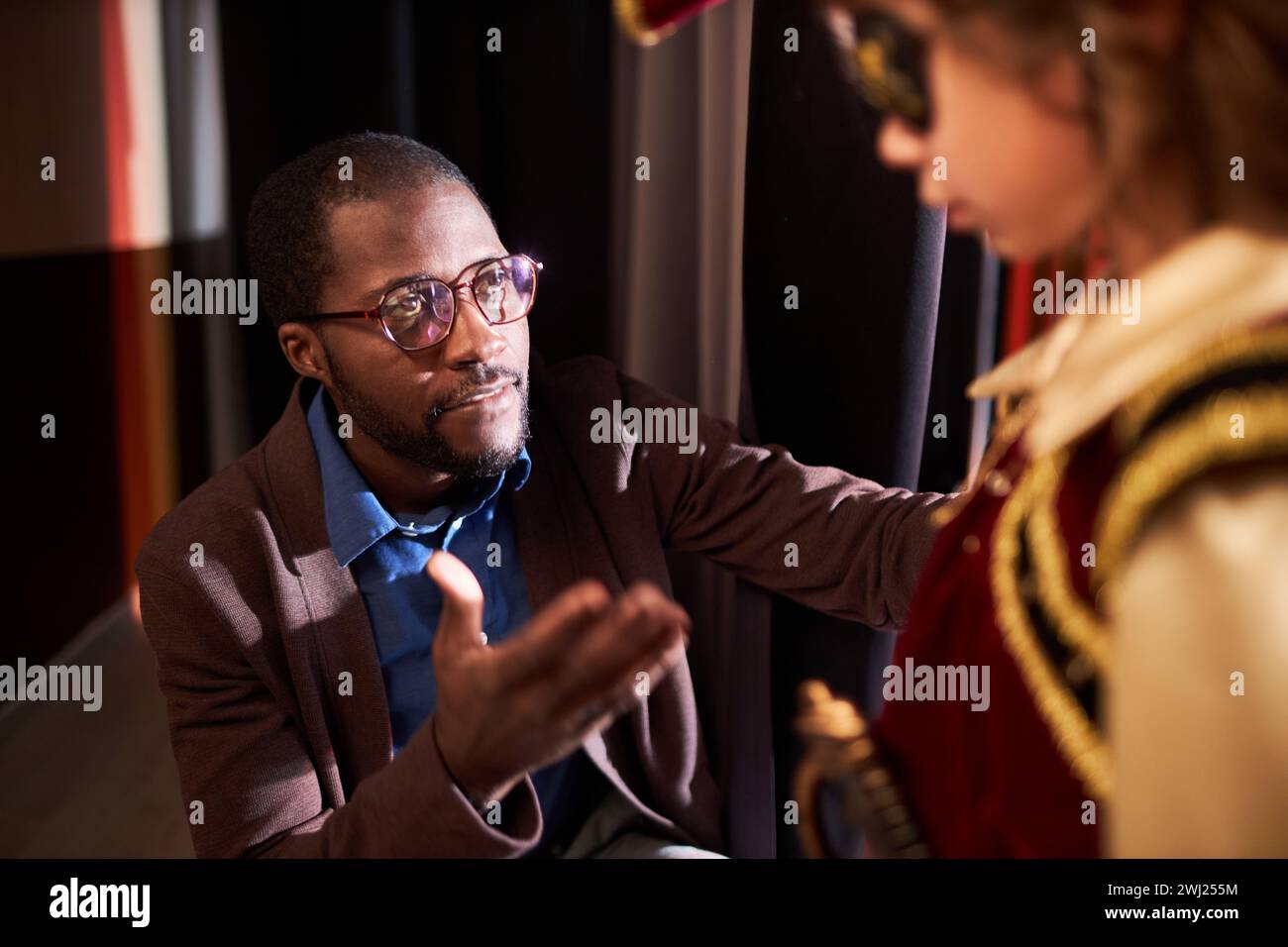 High angle portrait of caring African American drama teacher giving ...
