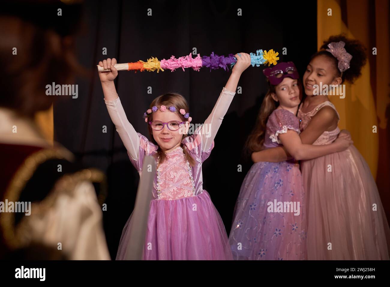 Portrait of cute little girl acting on stage as warrior princess ...