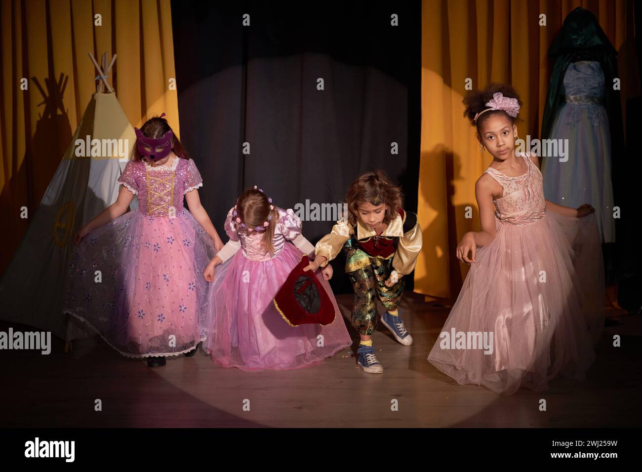 Full length portrait of group of children taking final bow on stage in ...