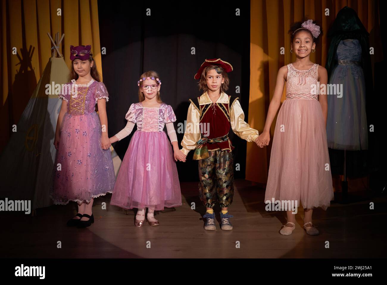 Full length portrait of group of children actors standing on stage ...