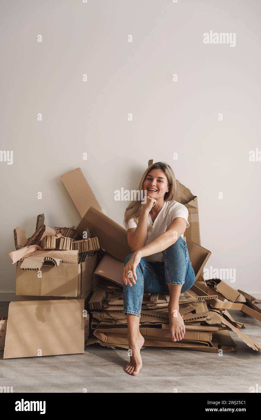 Young woman wand stack of cardboard waste at home. Concepts of Paper Recycling and Waste Sorting ...
