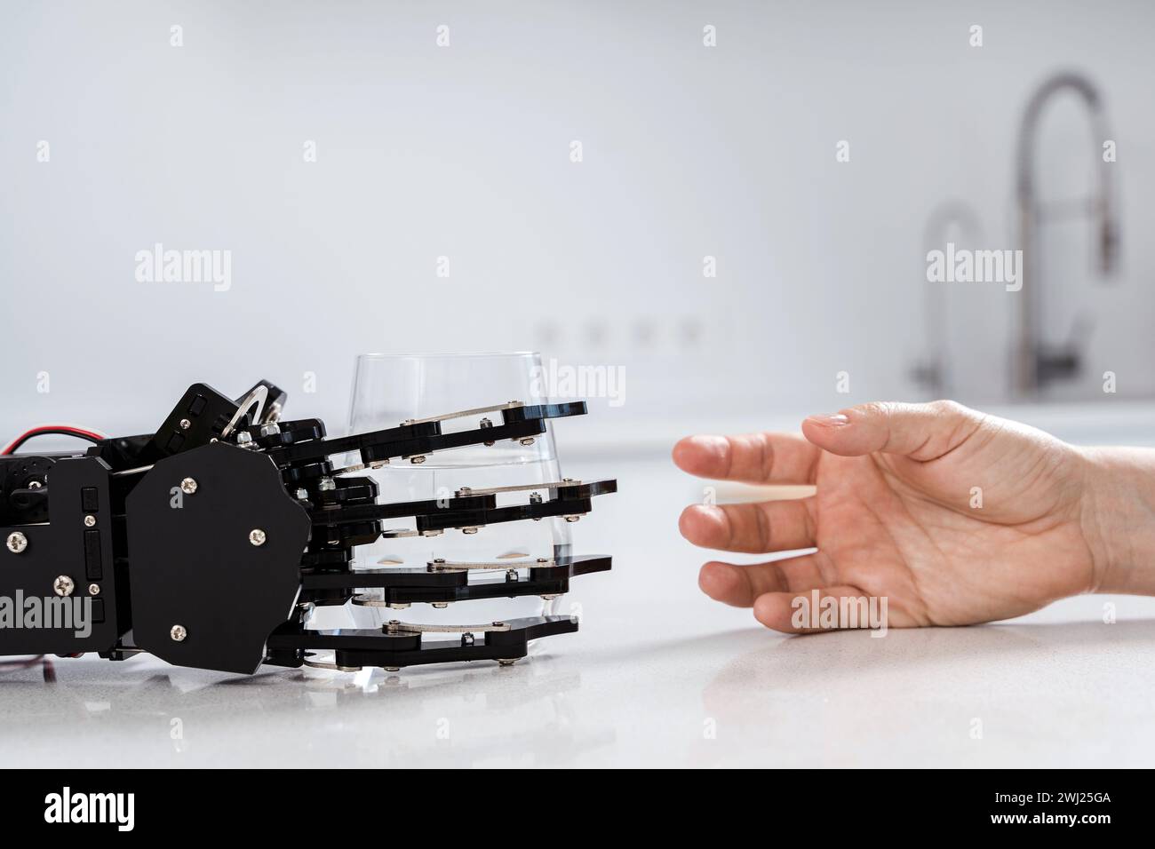Robotic caregiver extending a hand with a glass of water to young woman ...