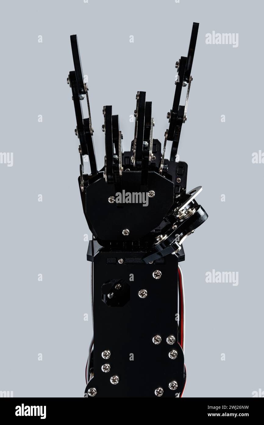 Real Robotic Hand Makes The Sign Of The Horns Against Grey Background