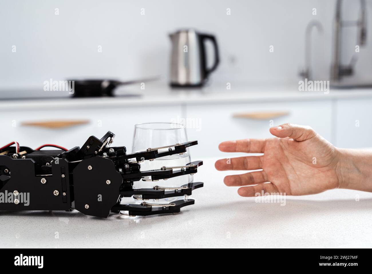 Robotic caregiver extending a hand with a glass of water to young woman ...