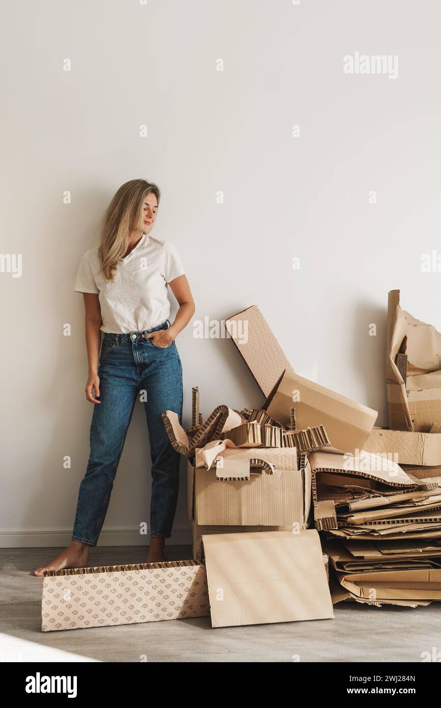 Young woman wand stack of cardboard waste at home. Concepts of Paper Recycling and Waste Sorting ...