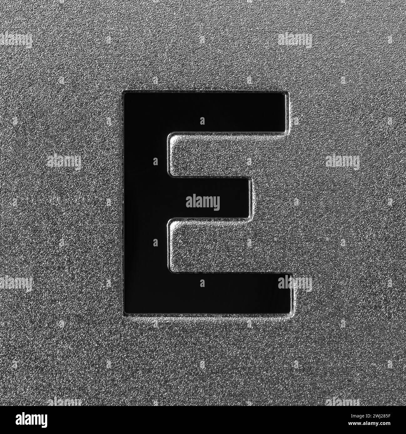 Letter E on a silver grained shiny metal surface. English alphabet ...