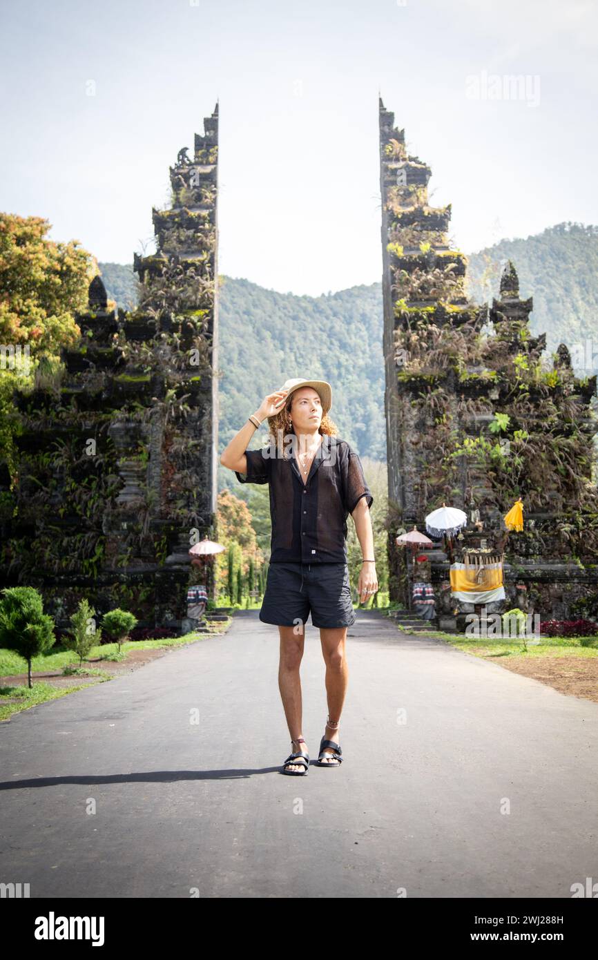 Male tourist walking in front of iconic Handara Gate of Bali Stock ...