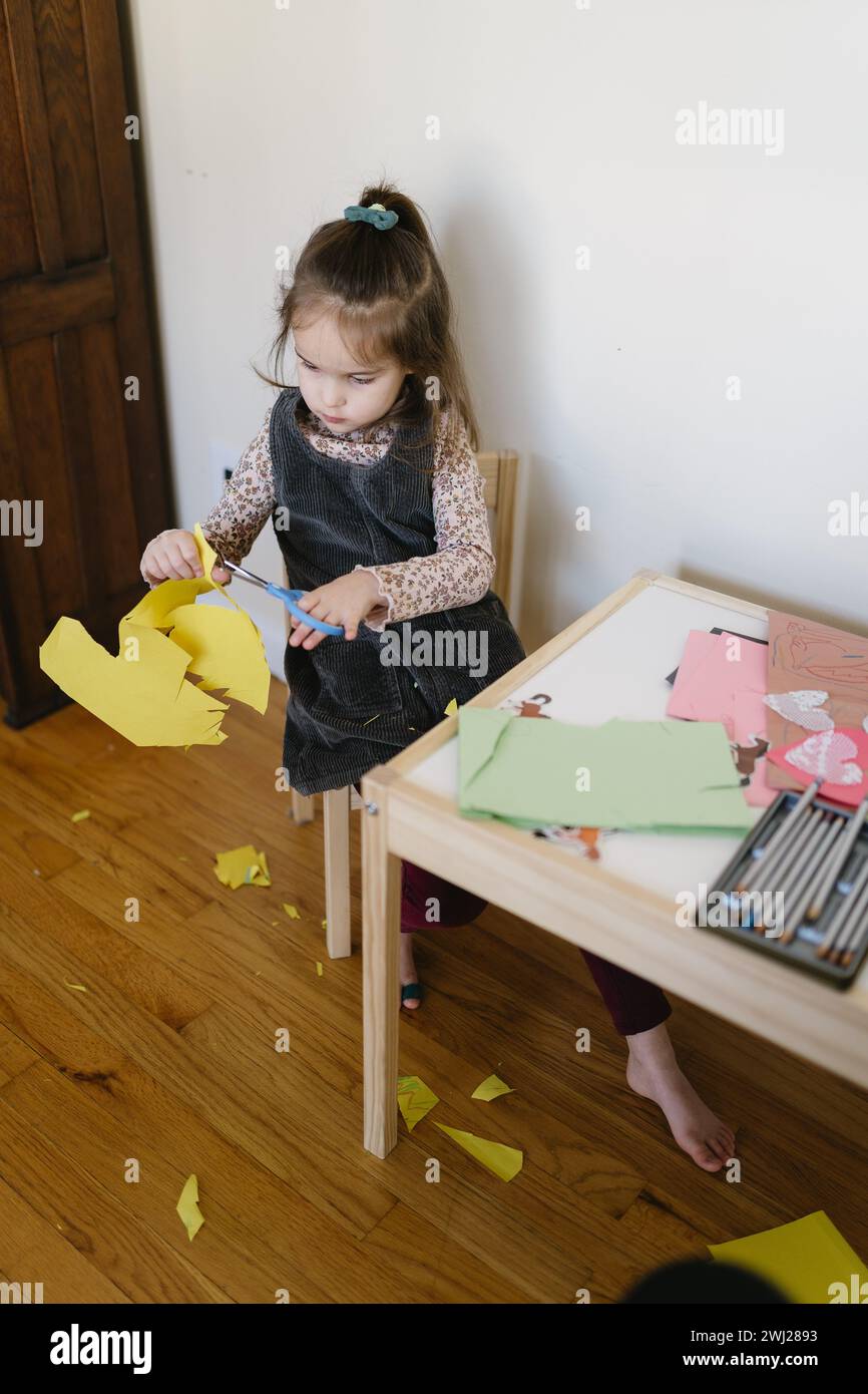 Toddler girl cutting construction paper, making a craft Stock Photo - Alamy