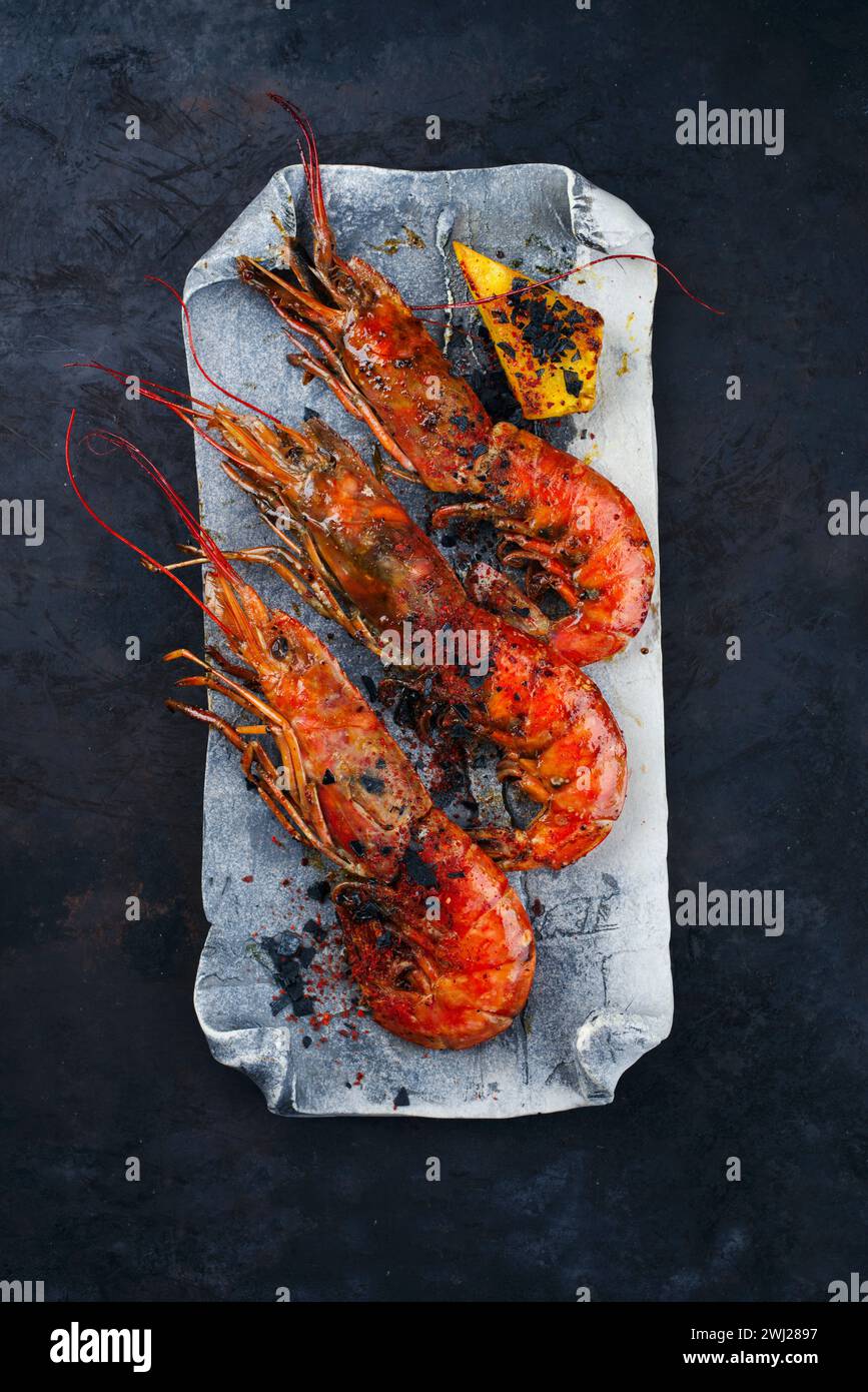 Traditional fried king prawns with pineapple pieces and black salt ...