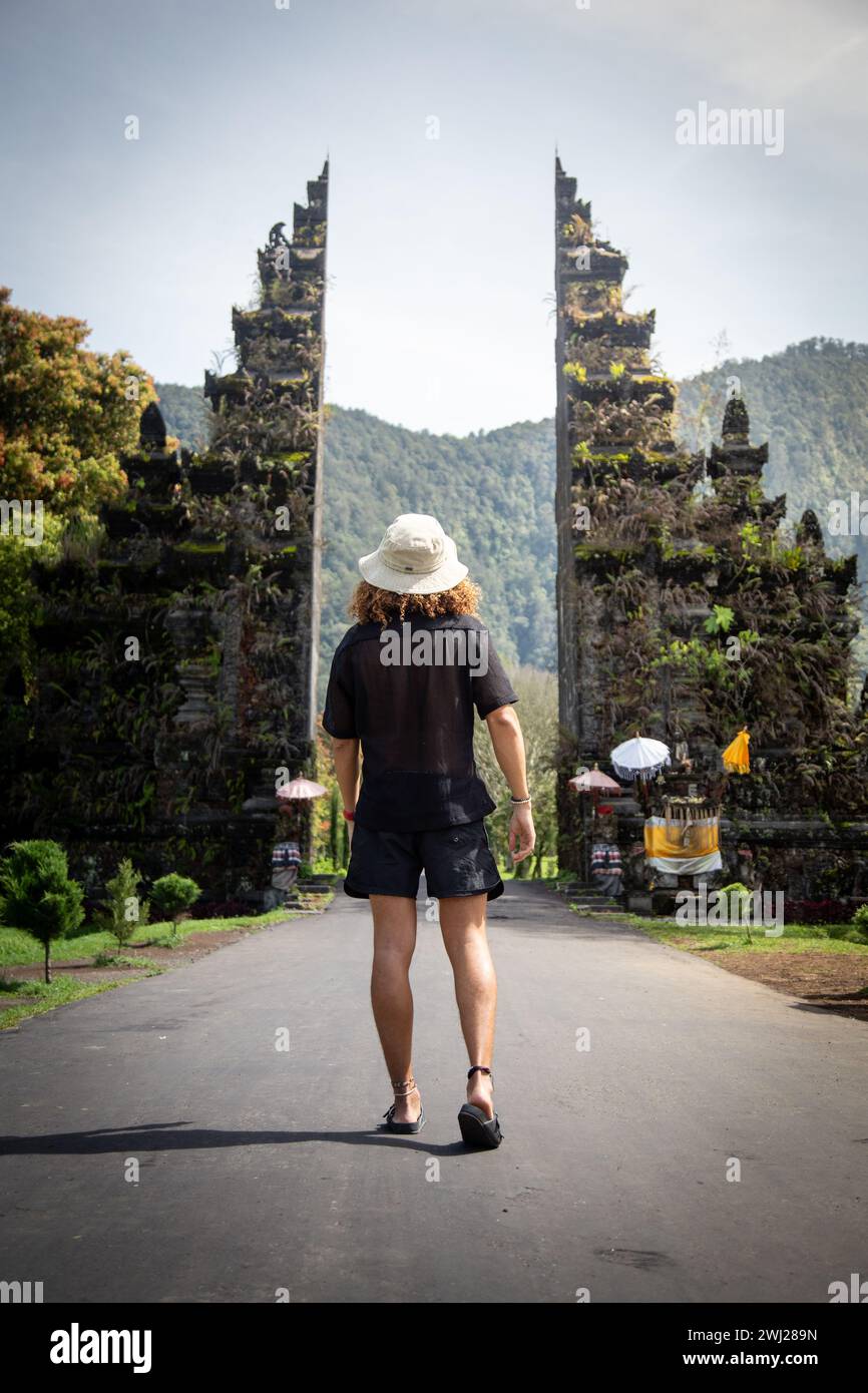 Male tourist walking towards the iconic Handara Gate of Bali Stock ...