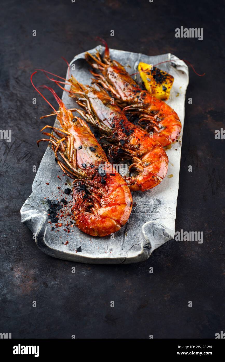 Traditional fried king prawns with pineapple pieces and black salt ...