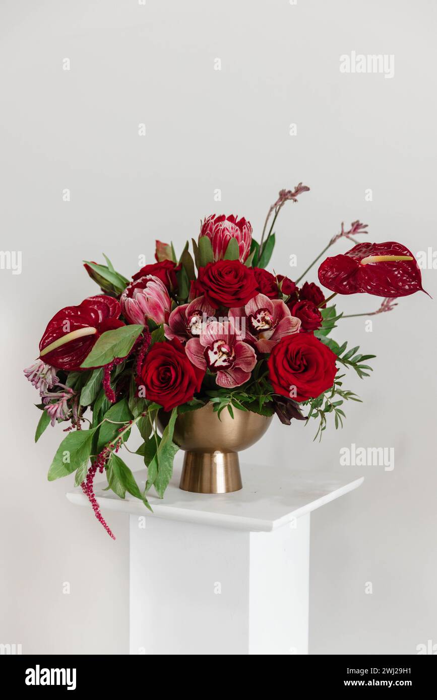 Vibrant Large Shades of Red Floral Arrangement in Gold Vase Stock Photo ...