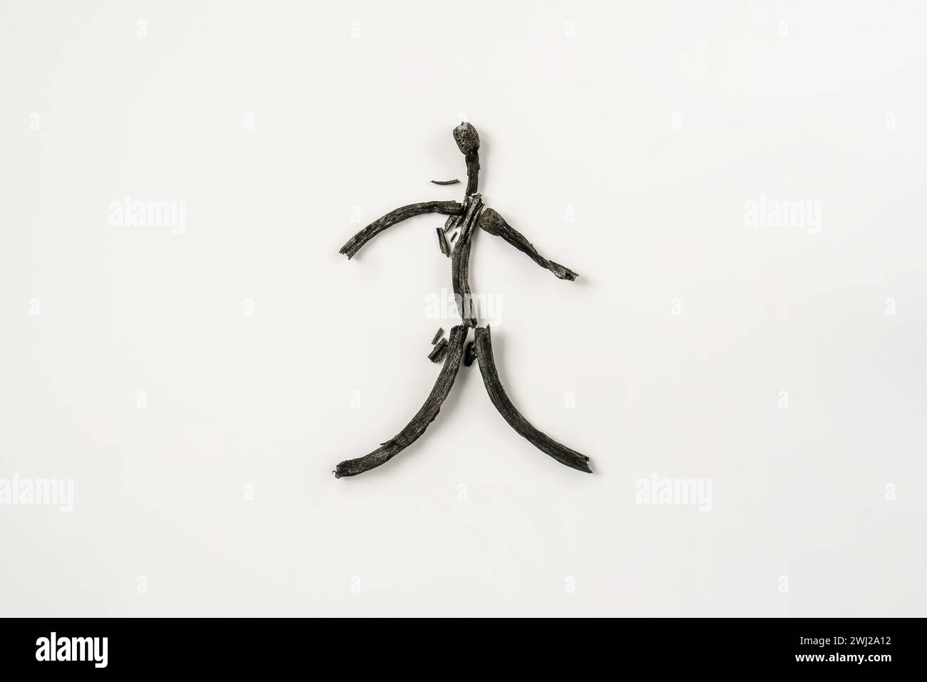 A human figure made of burnt charred matches on a white background. The ...
