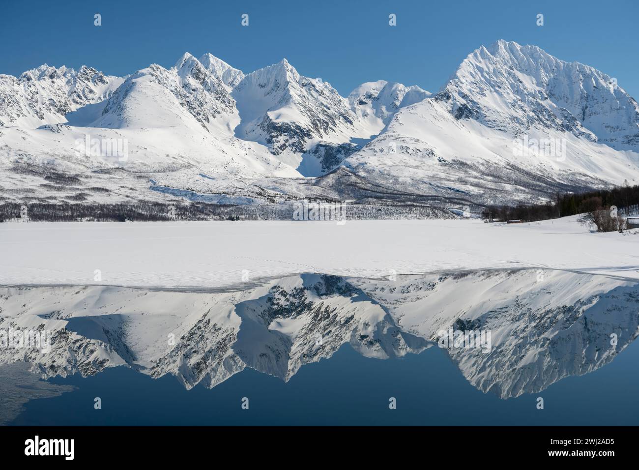 Reflection of snow covered mountains on ocean Stock Photo - Alamy