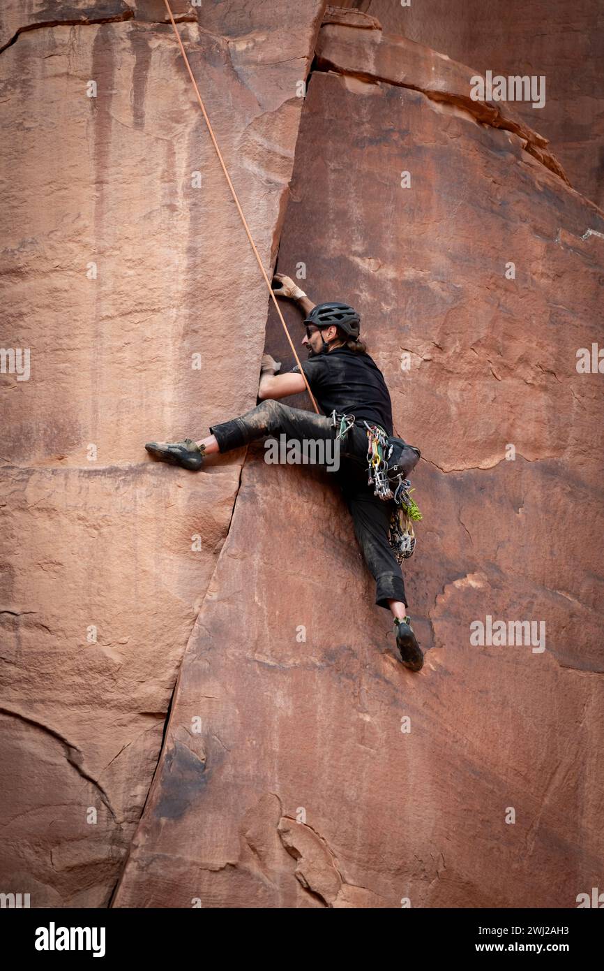 Low angle view of man rock climbing at desert Stock Photo - Alamy