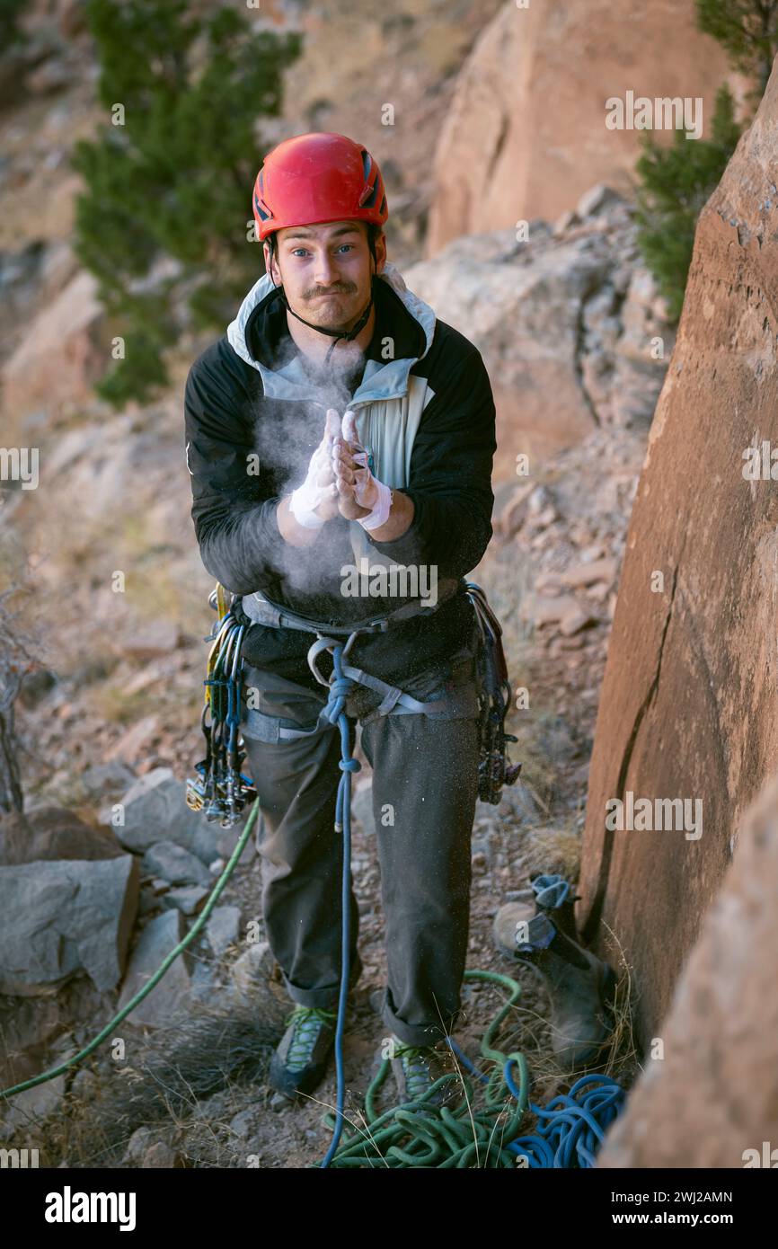 Man with powder in hands getting ready for rock climbing at desert ...