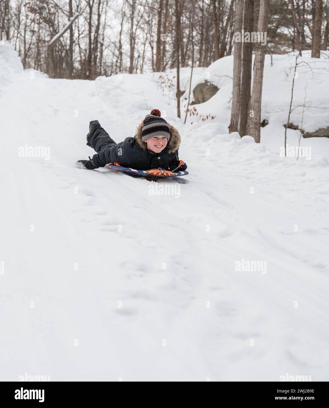 Boy sledding down hill hi-res stock photography and images - Alamy