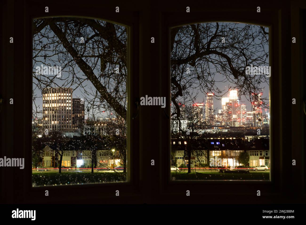Seen through a bay window of a residential home and the branches of ...