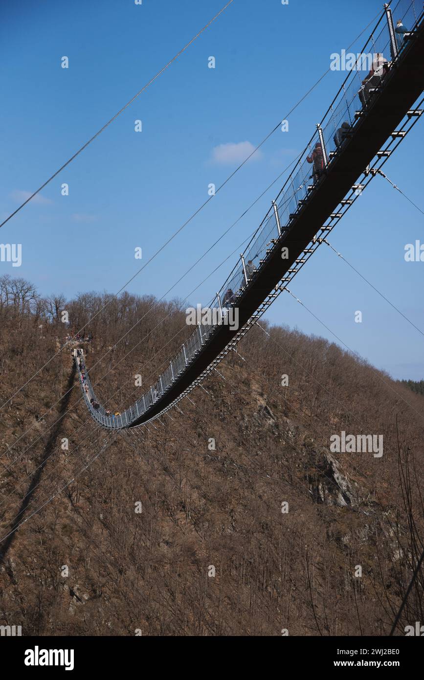 Suspension bridge from below with people walking by Stock Photo - Alamy