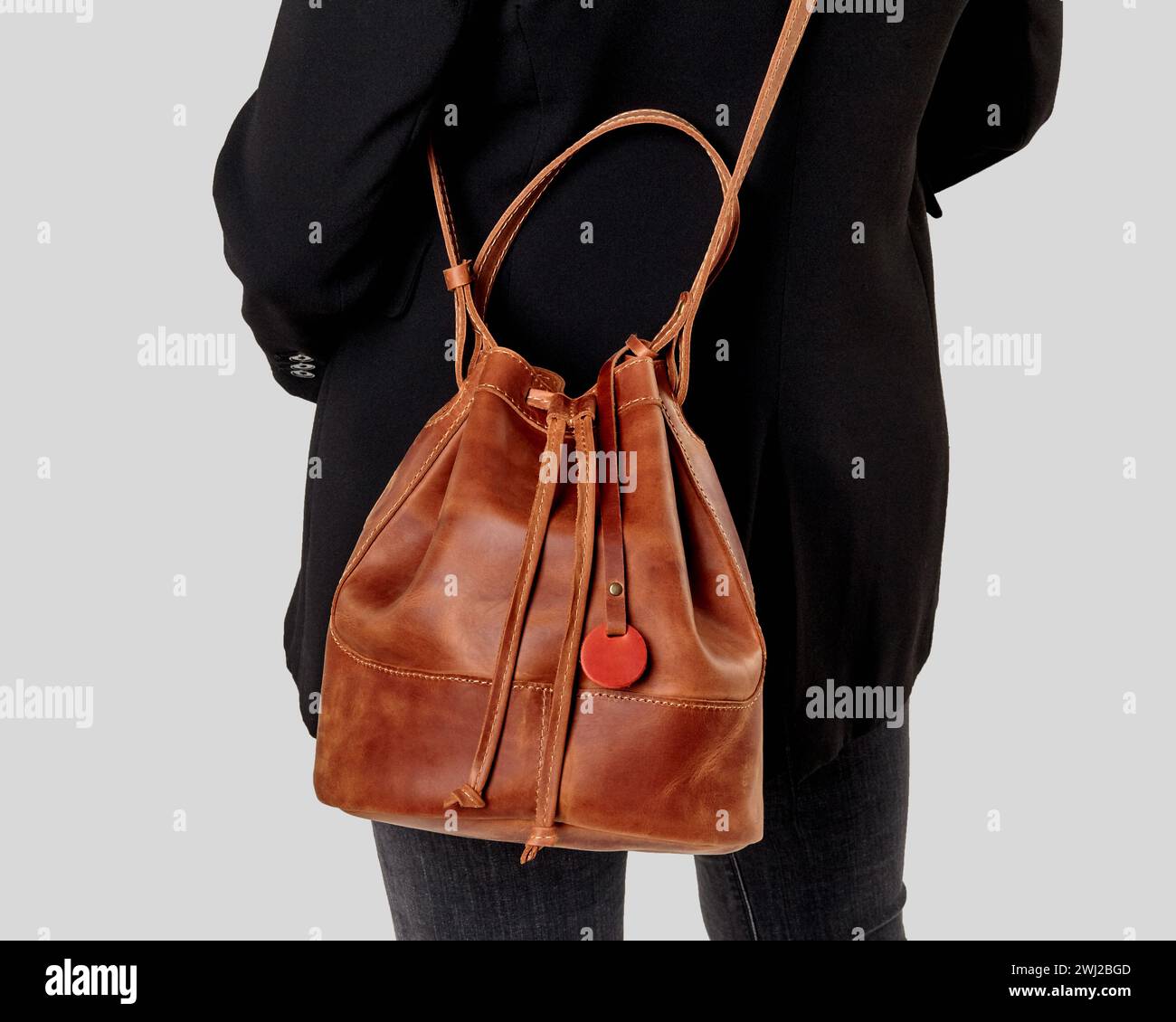 Woman carrying stylish tan leather bucket bag over shoulder Stock Photo ...