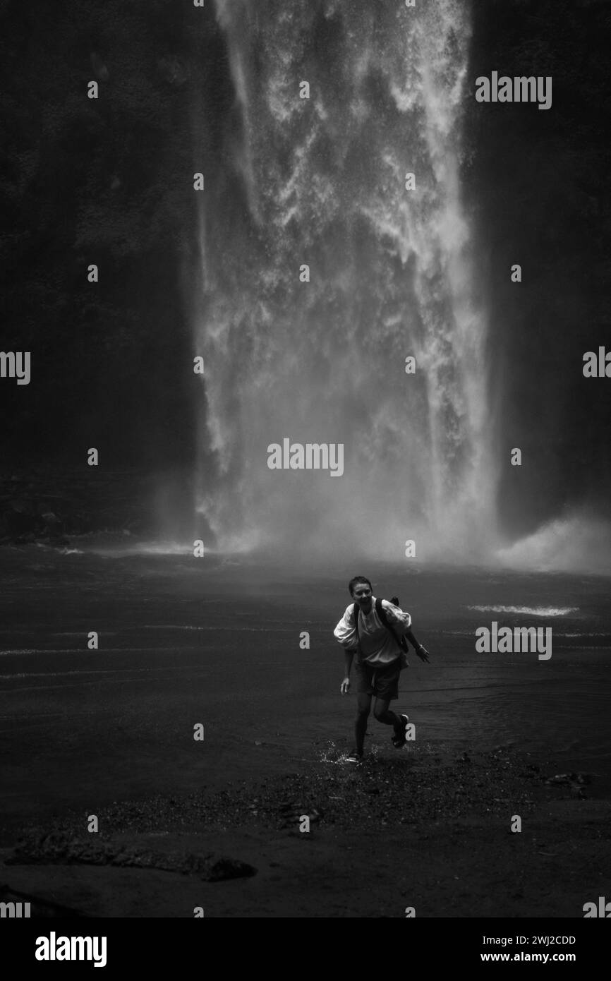 Woman traveler, explorer with backpack in jungle, at waterfall Stock ...