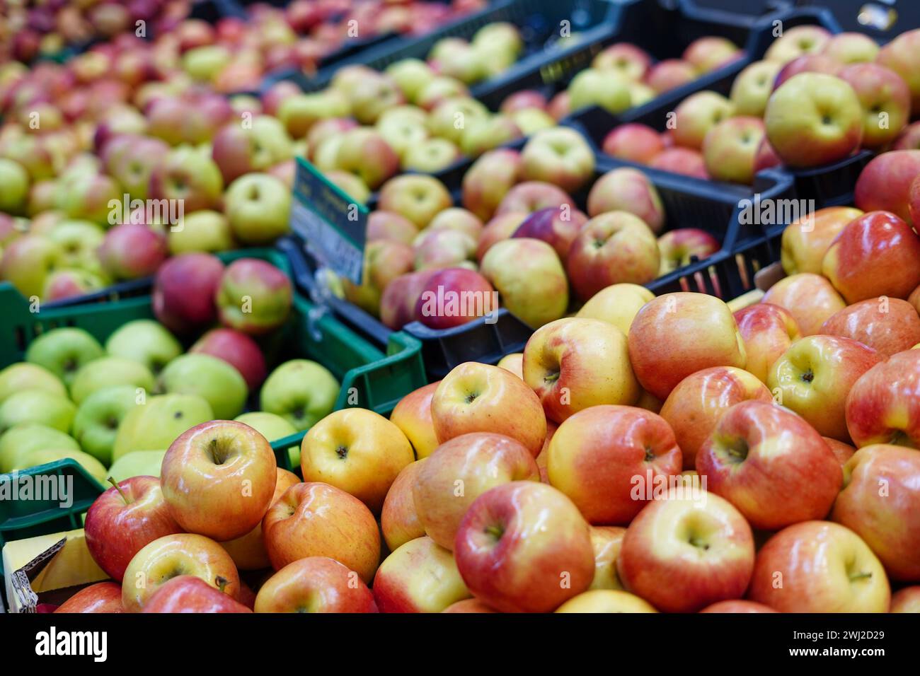 Red and green apples in the boxes in big grocery store. ripe apples ...