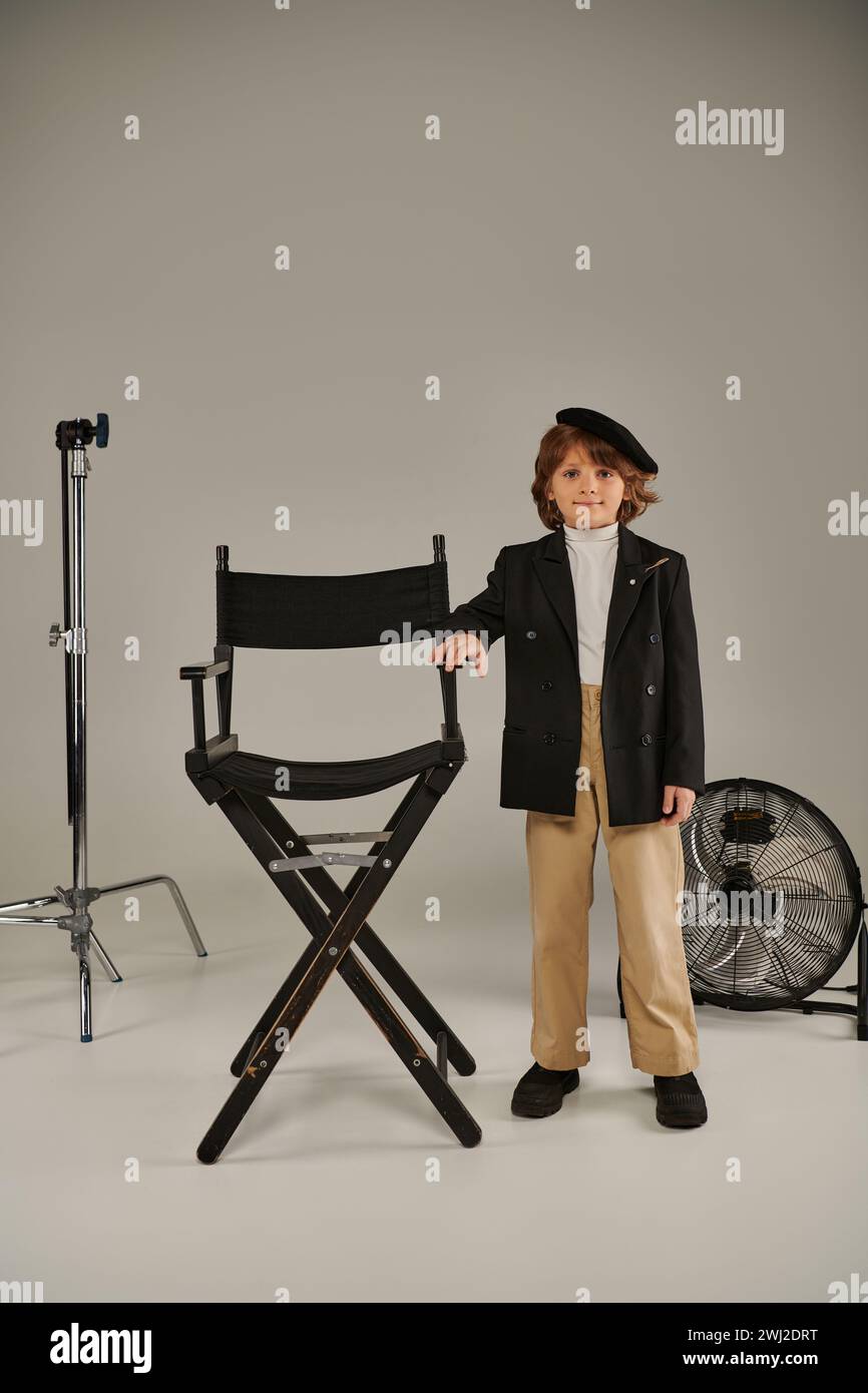 stylish boy in beret and smart casual attire stands confidently near ...