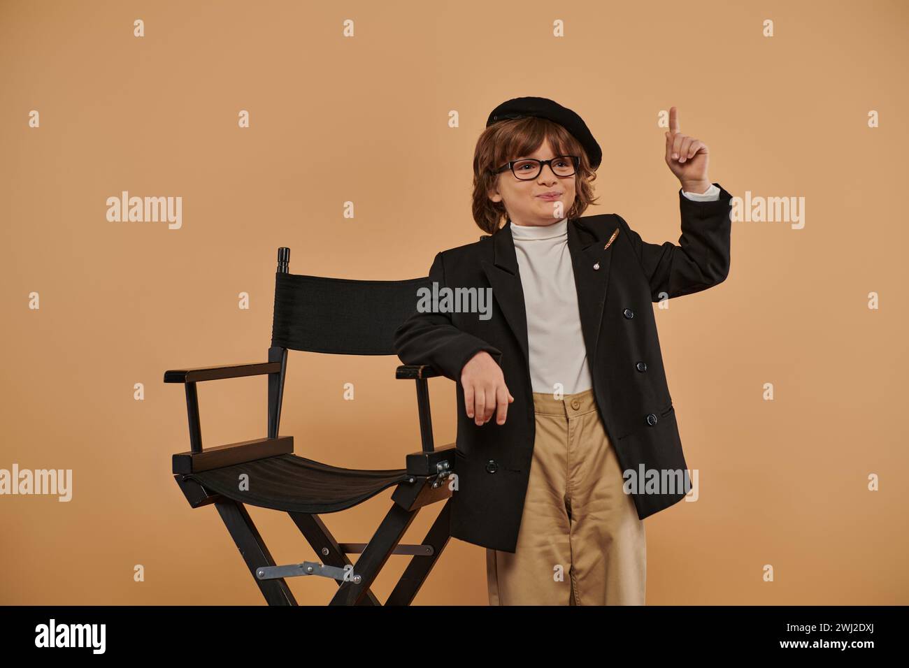 happy boy standing near director chair, with a smile on face showing ...
