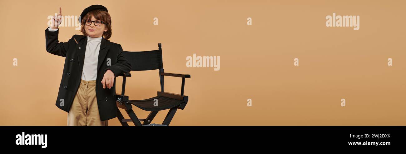 boy standing near director chair, with a smile on face showing idea ...
