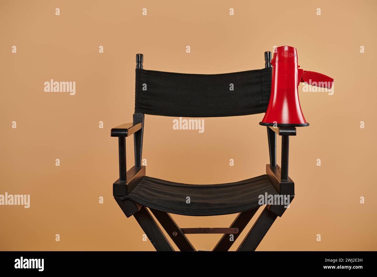 a director chair with a red megaphone on beige background ...